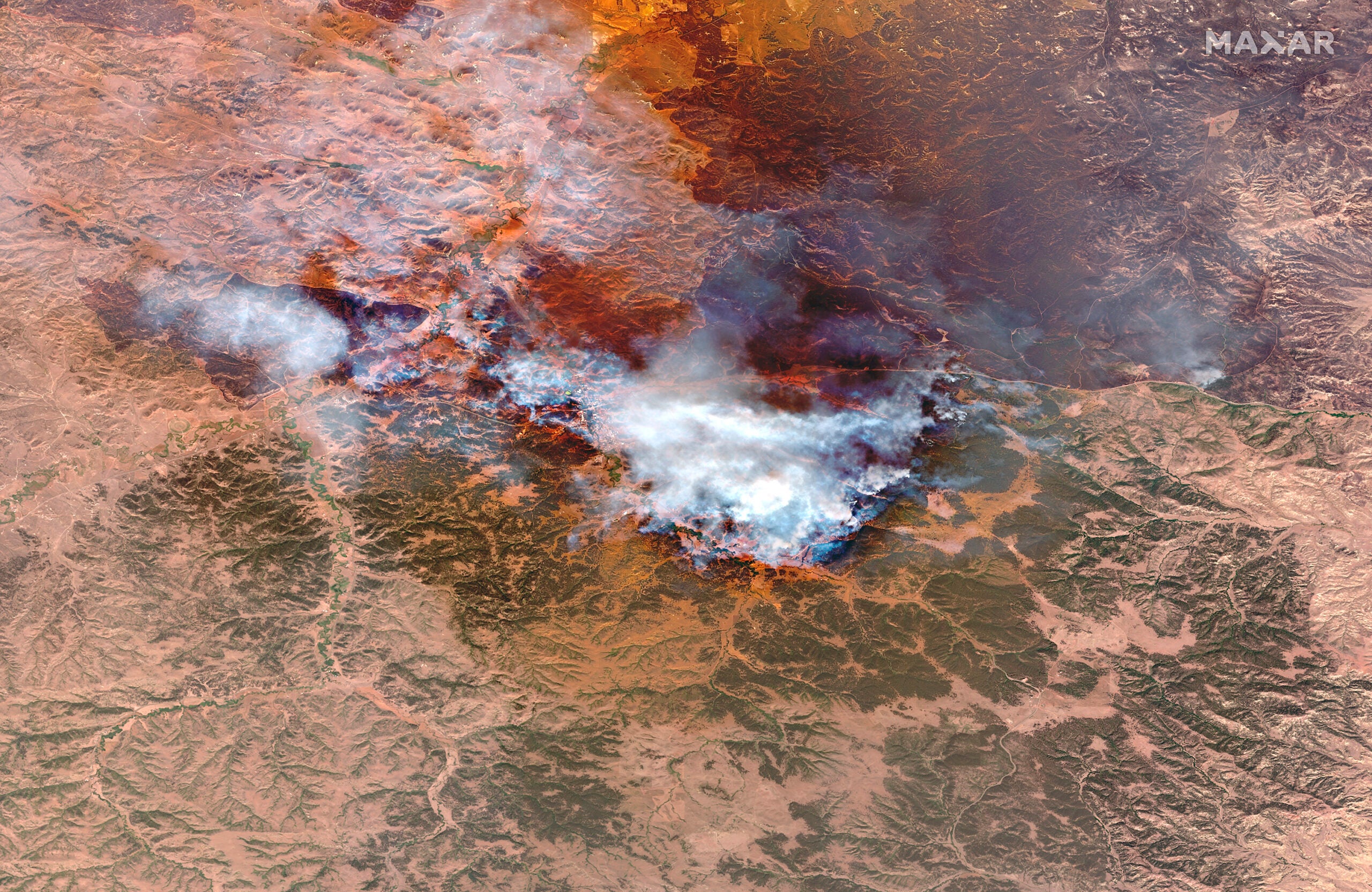 Western fires threaten thousands of homes, strain resources