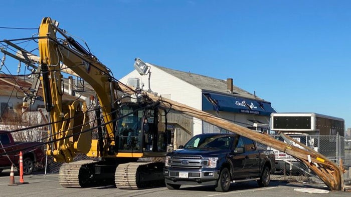 Construction worker rescued after utility pole, live wires crash onto ...