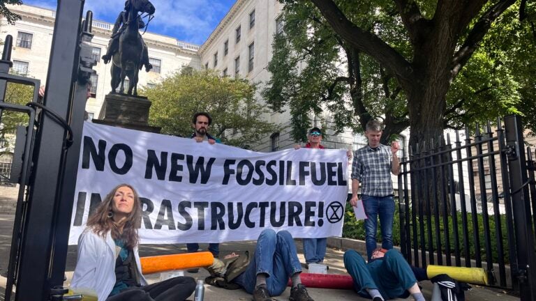 Climate protesters chain themselves to State House gate